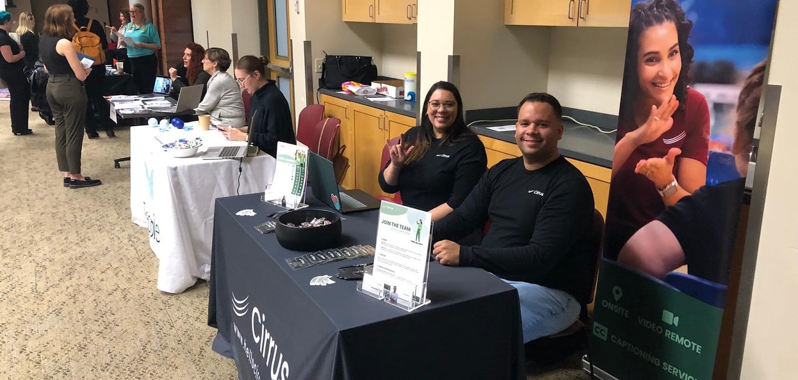 people conversing with and signing with career fair agencies